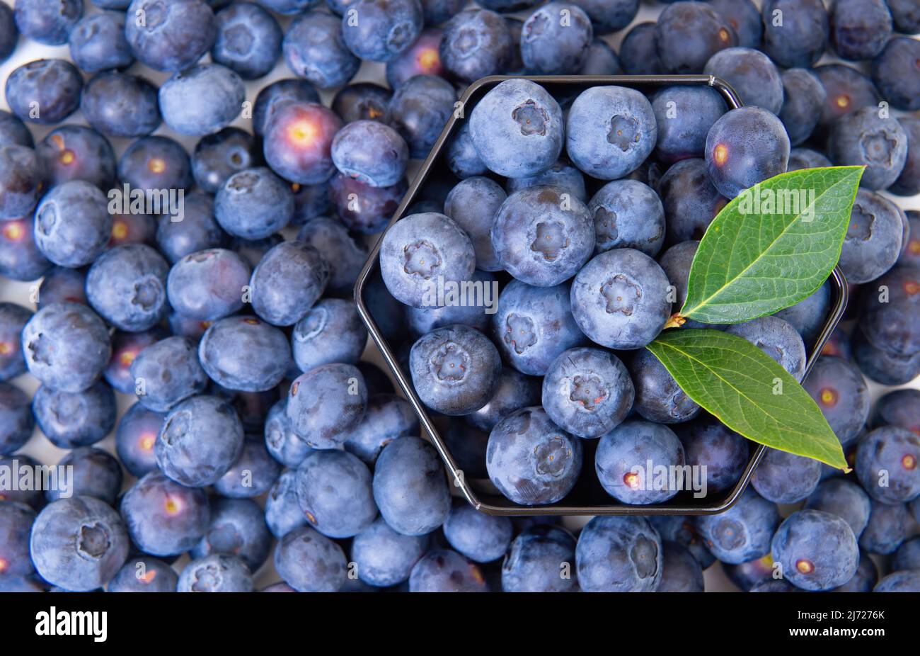 Hexagonal box with fresh ripe blueberries on berries background Stock ...