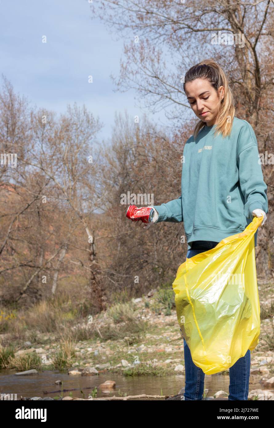 Woman stand up with a can on her hands cleaning up litter with a ...