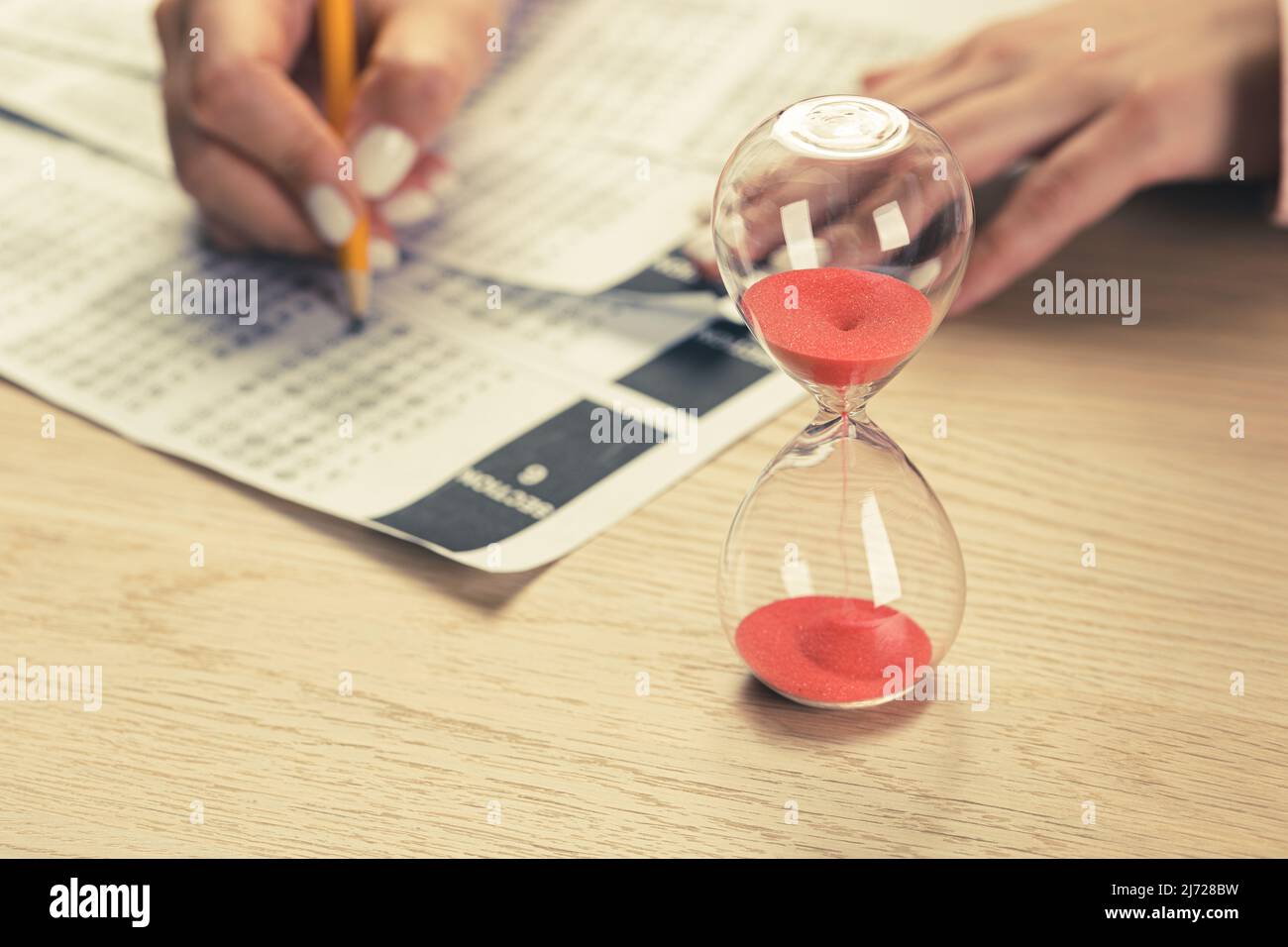 Hourglass with time running out and student hand testing in exercise ...