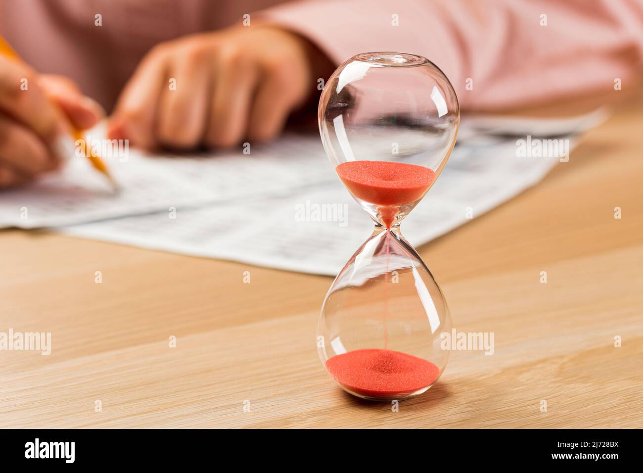Hourglass with time running out and student hand testing in exercise ...