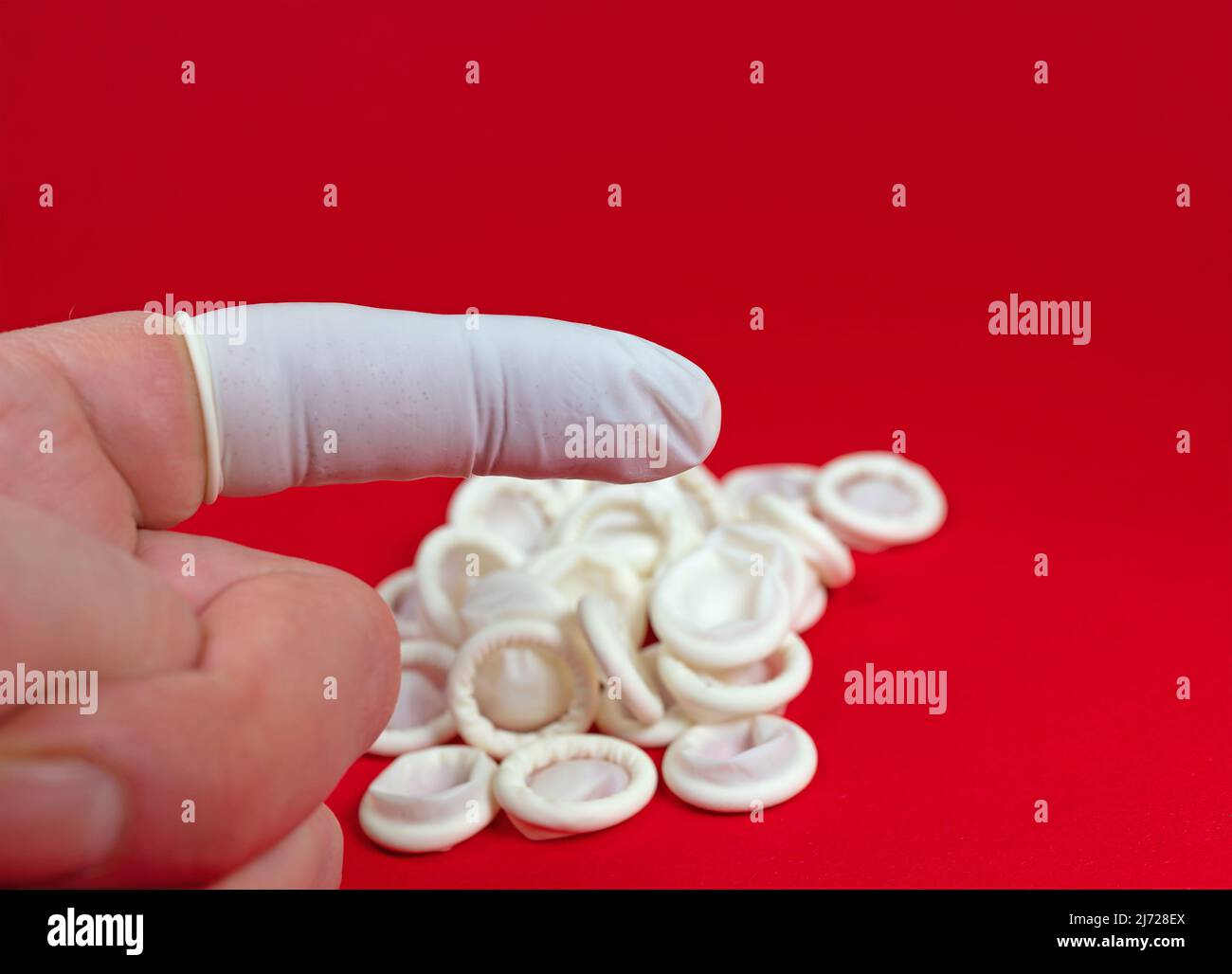 Latex finger stalls against a red background Stock Photo - Alamy