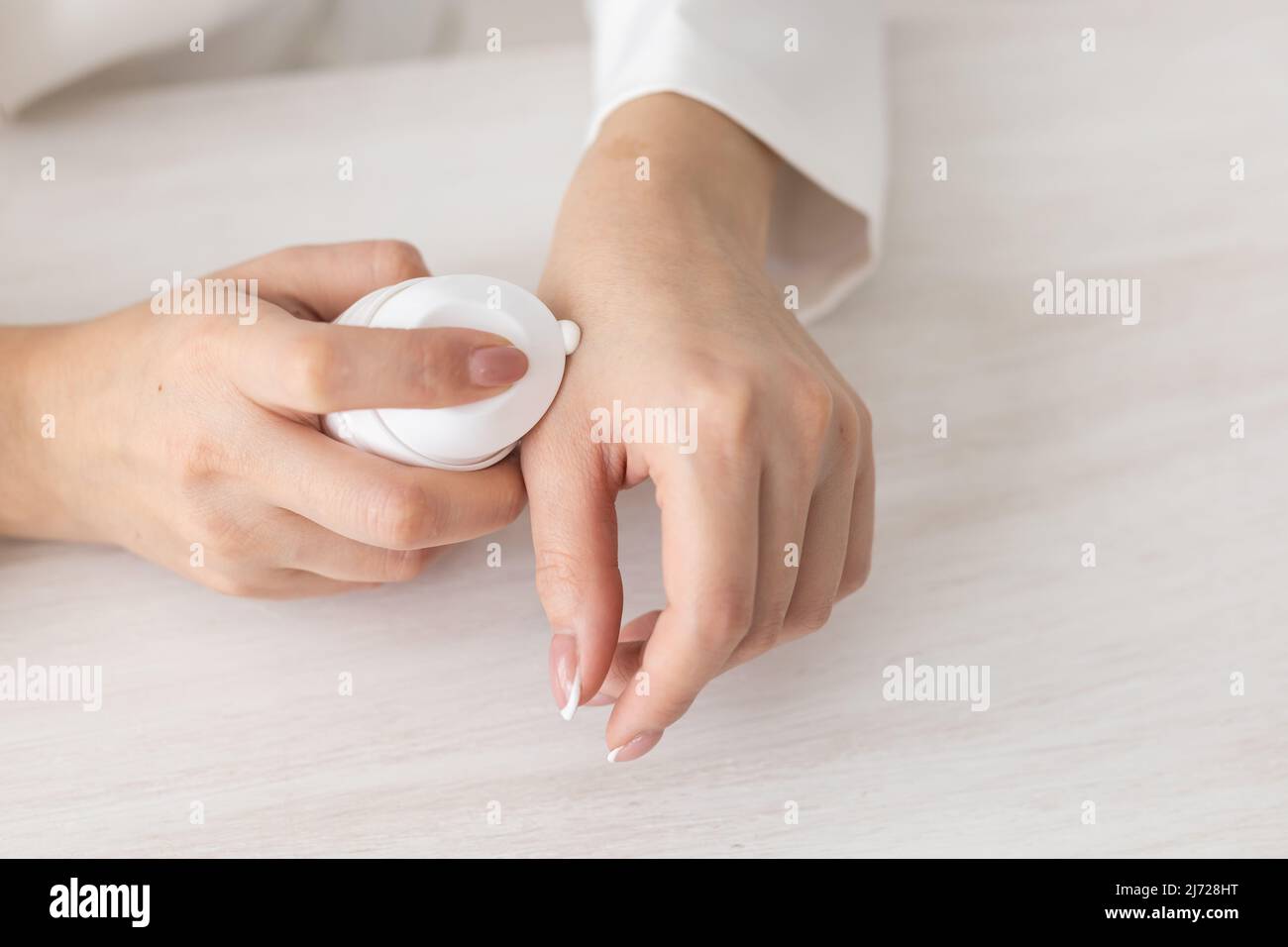 Female hands with cream. Woman applies cream on her hands. Palms down ...