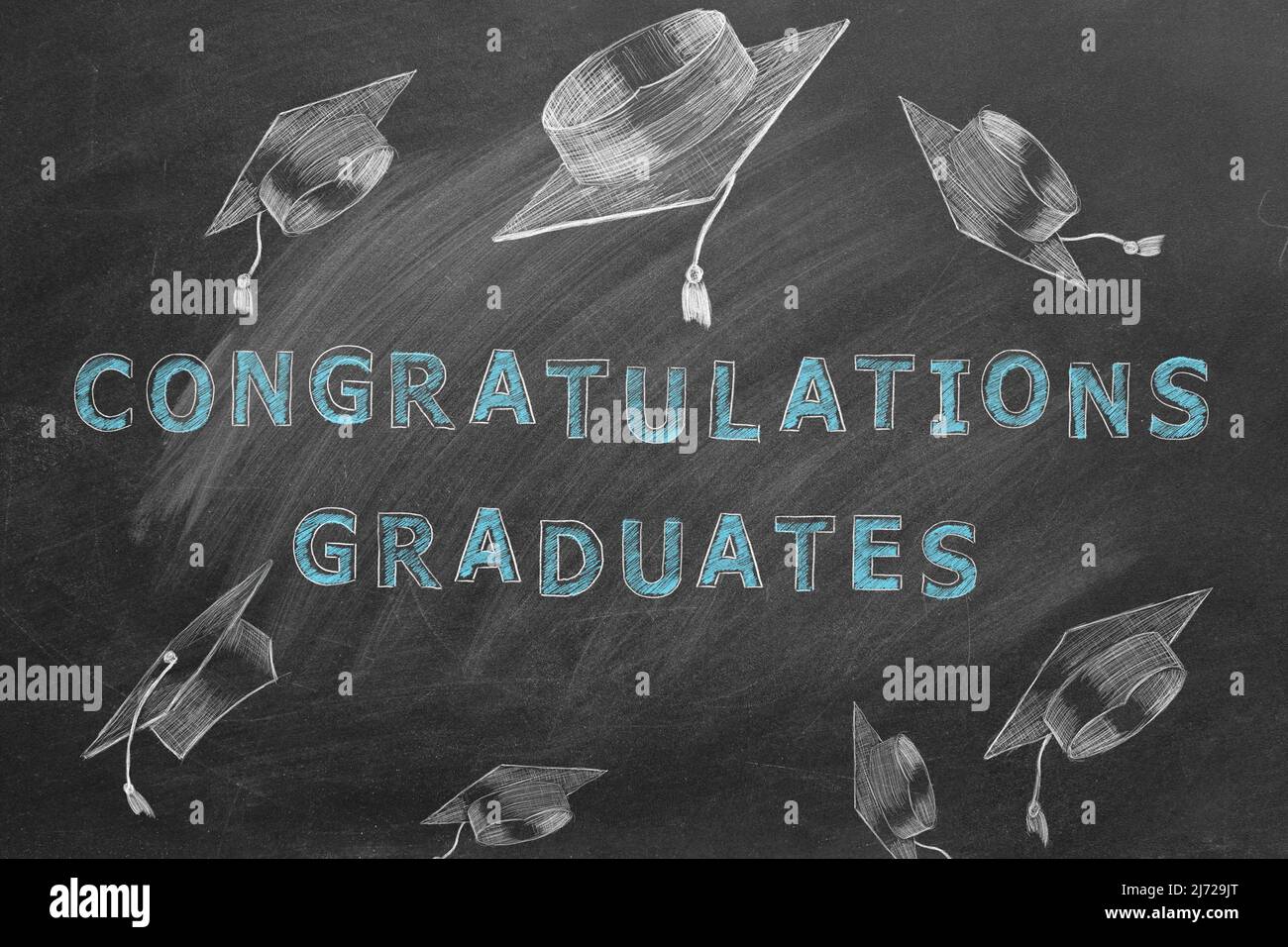Hand drawing text CONGRATULATIONS GRADUATES and graduation caps on ...