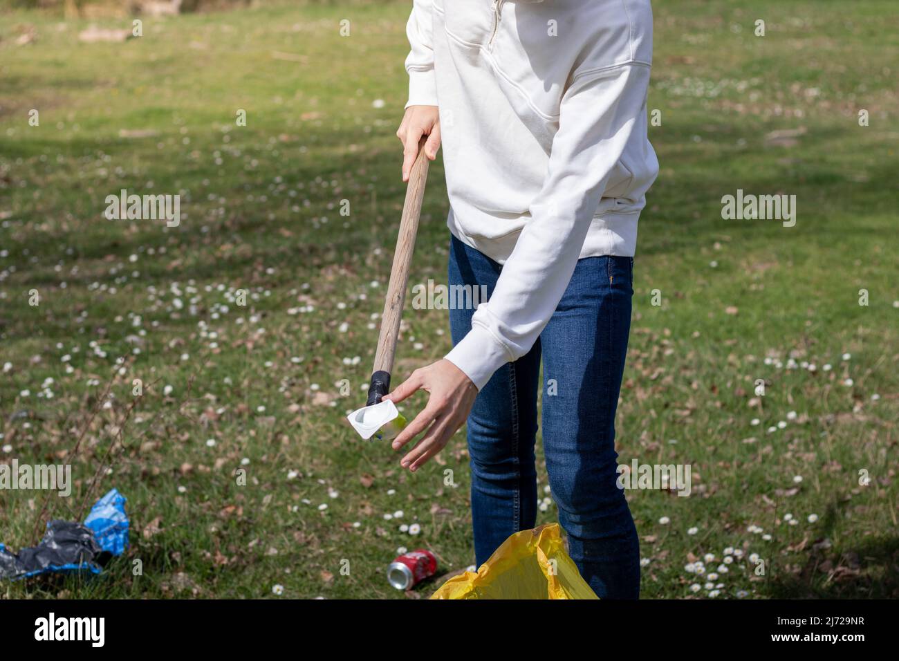 Unrecognizable young man collecting plastic from the ground in a ...