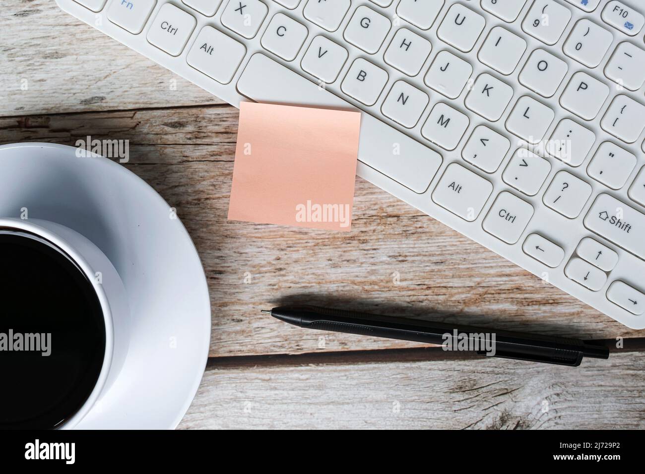 Directly above view of office desk with sticky note on computer ...