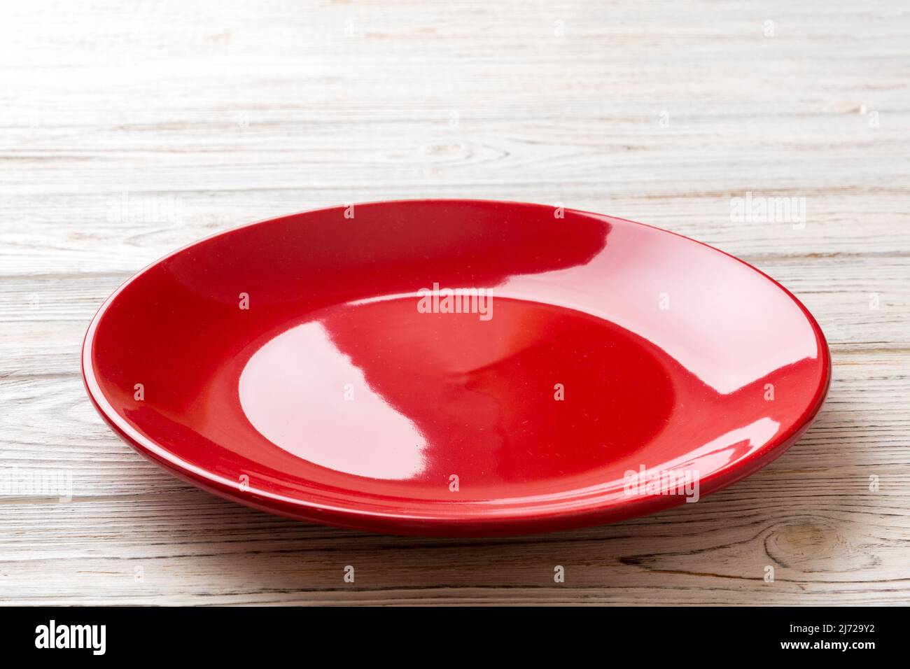 Perspective view of empty red plate on wooden background. Empty space ...