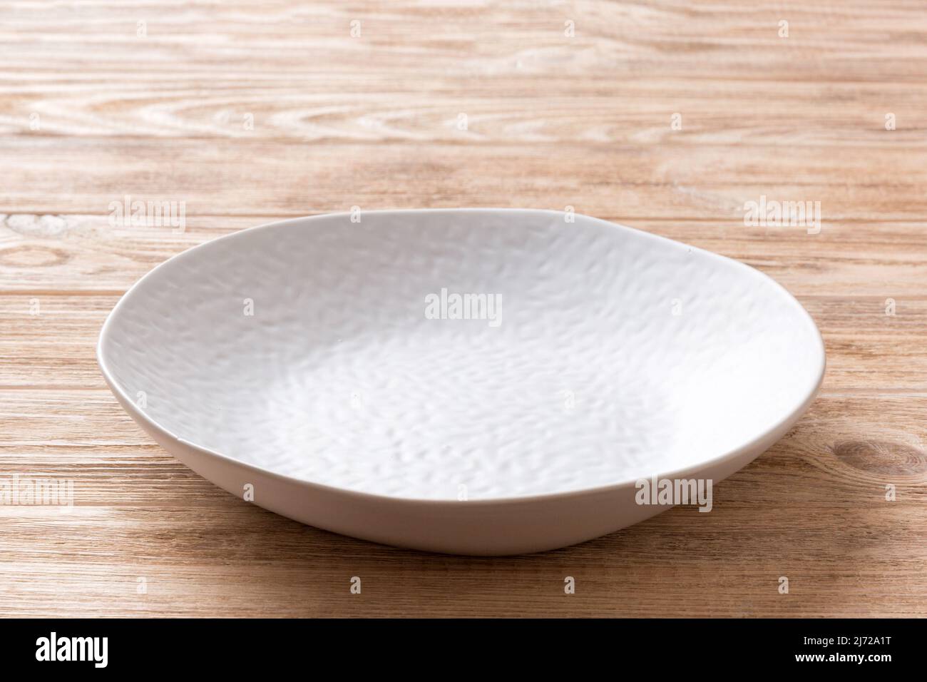 Perspective view of empty light plate on wooden background. Empty space ...