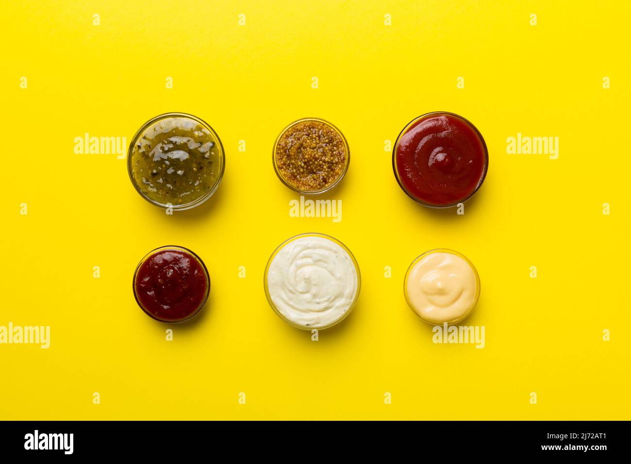 Different types of sauces in bowls on a colored Board . Top view ...