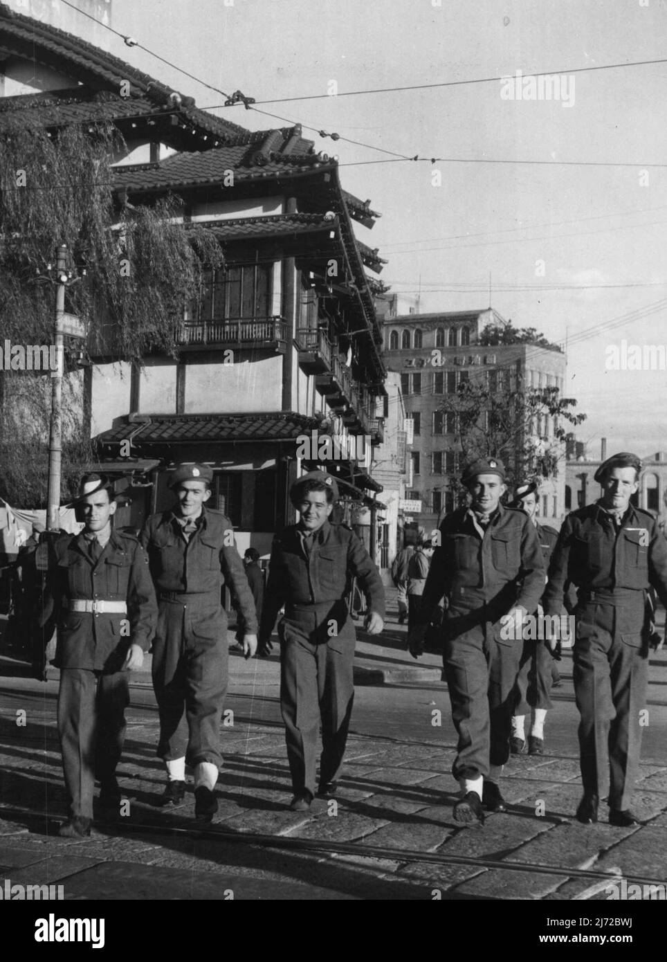 Troops in Tokyo streets note old and new style buildings. November 27 ...