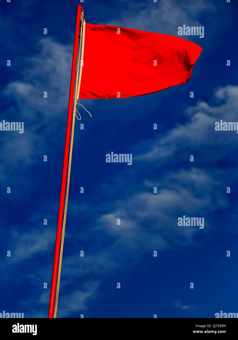 red flag to signal the danger of very rough sea on blue sky Stock Photo ...