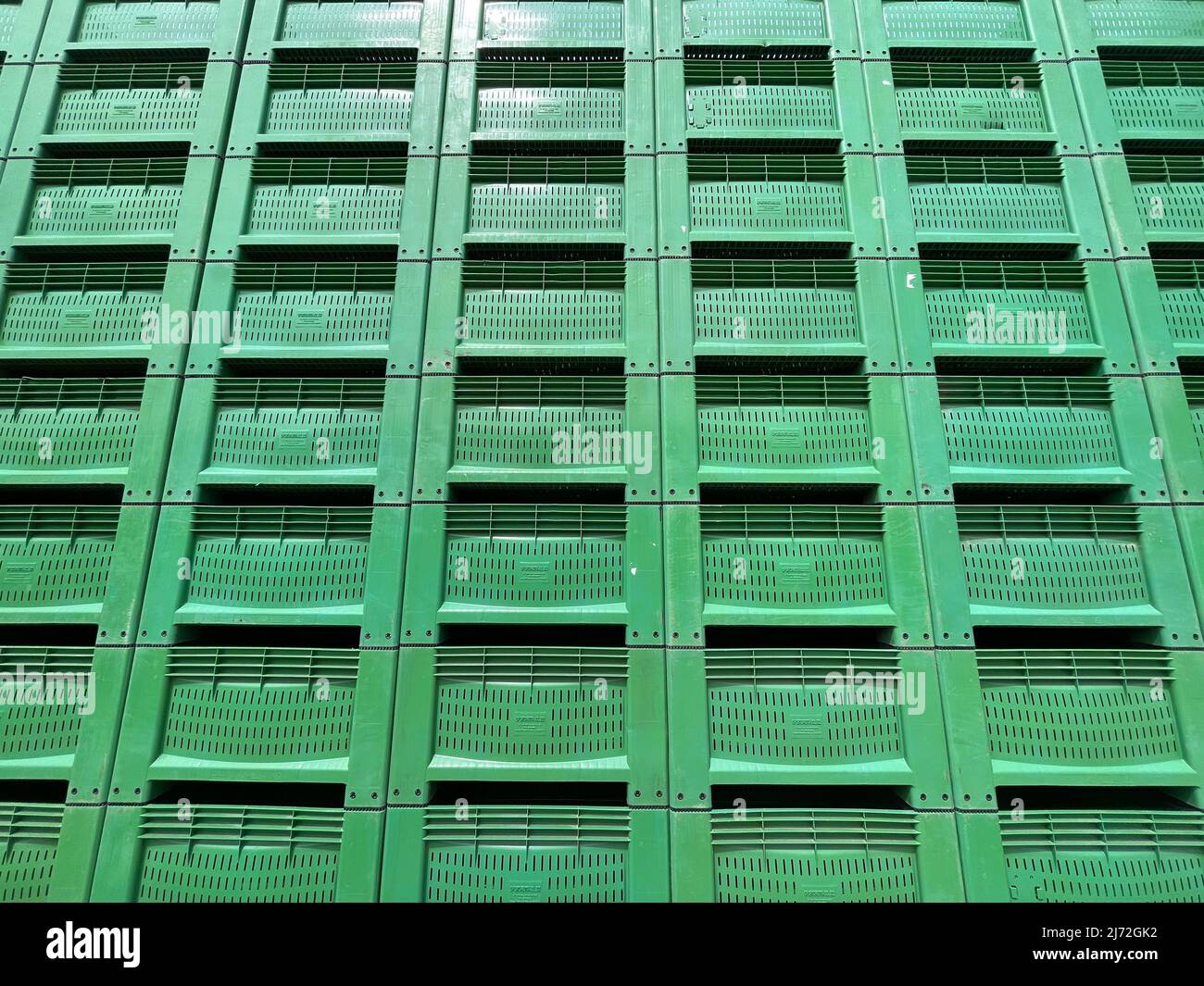 Tall stack of green color new plastic packaging crates background Stock ...