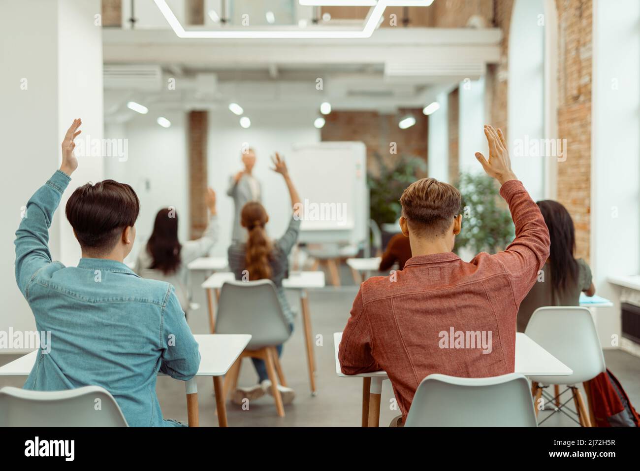 Students are raising their hands for answer Stock Photo - Alamy