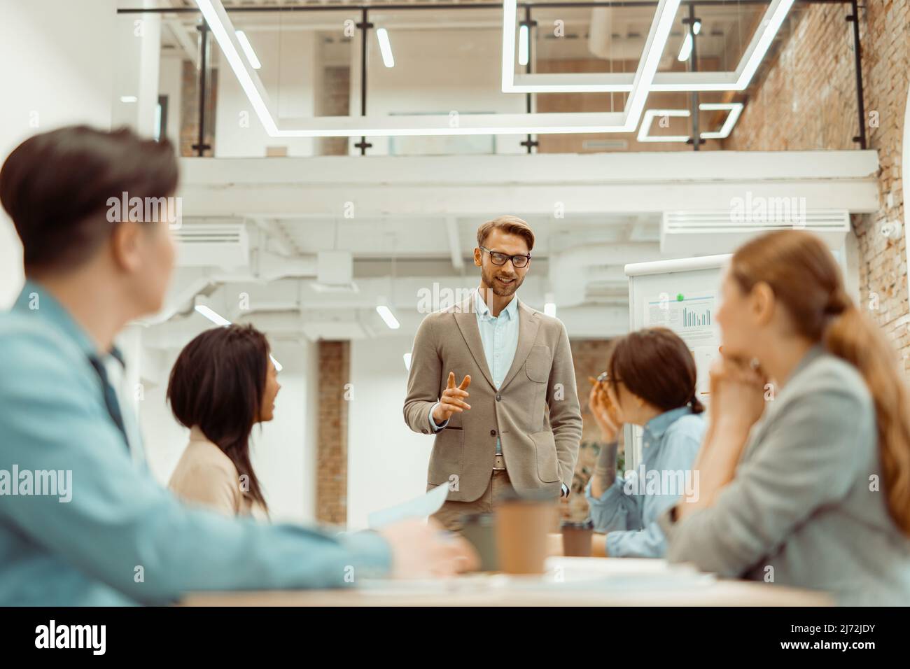 Man standing in office and explaining new ideas to colleagues Stock ...