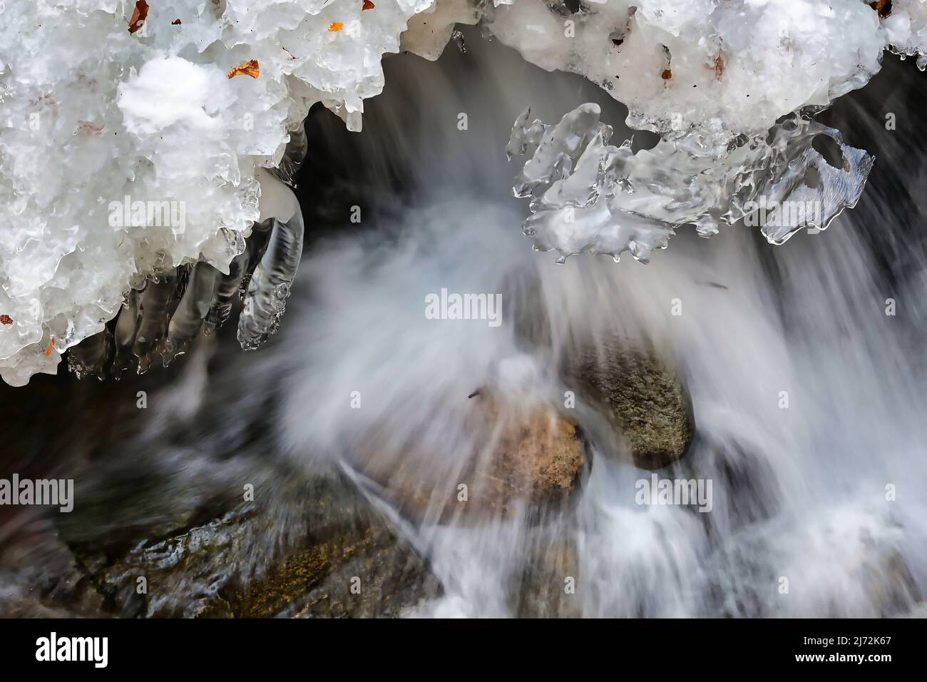 water flowing from the frozen ice Stock Photo - Alamy