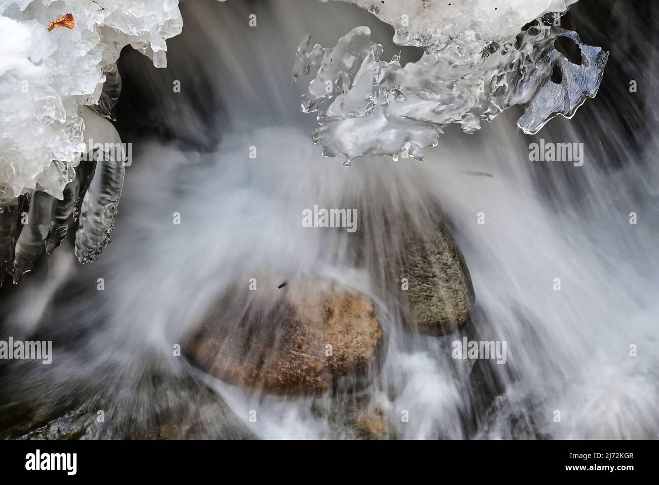 water flowing from the frozen ice Stock Photo - Alamy