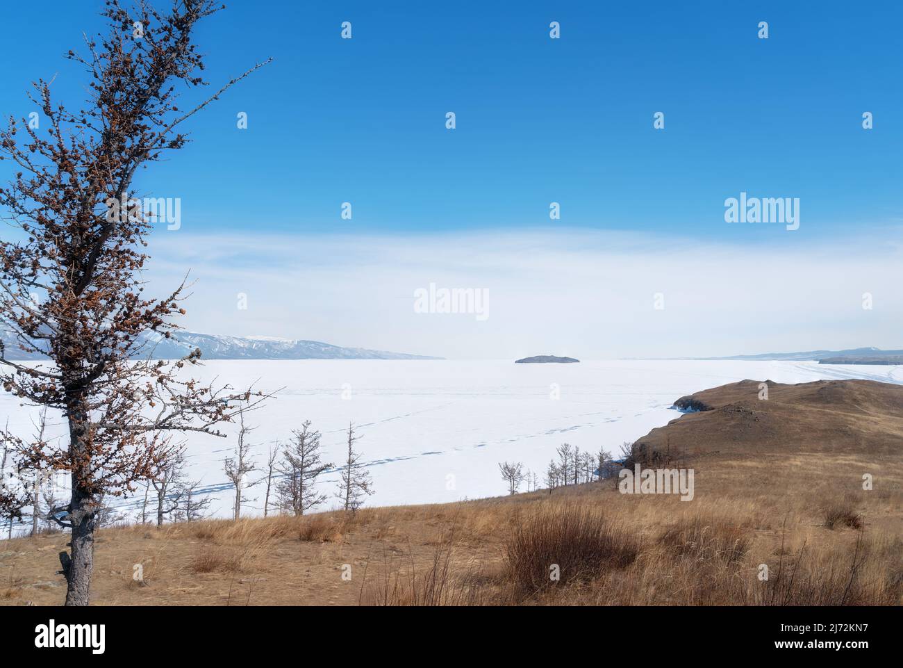 Winter landscape with mountains and dark blue ice of Baikal Lake in ...