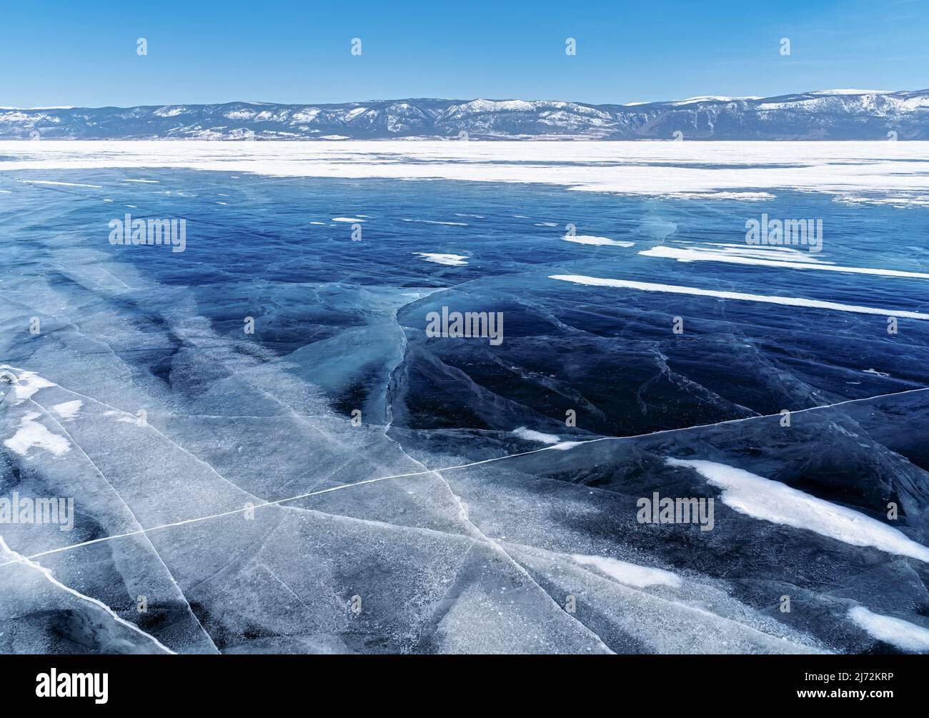 Winter landscape with mountains and dark blue ice of Baikal Lake in ...