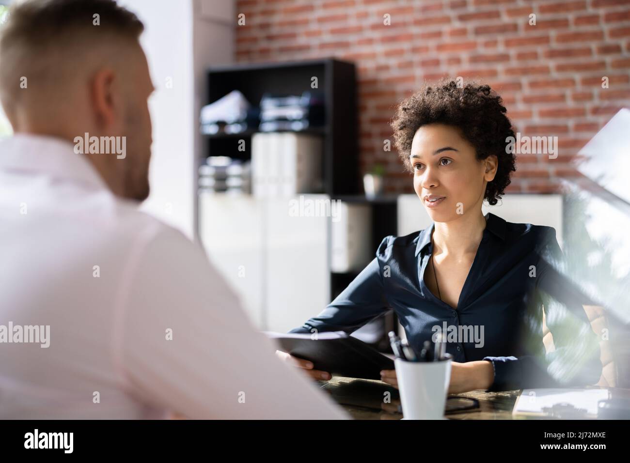 Mature Businesswoman Taking An Interview Of Man Over The Wooden Desk In ...