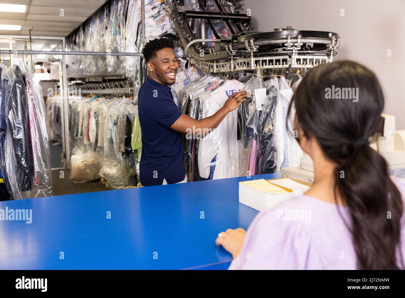 Small business owner of a dry cleaners talking with customer while ...