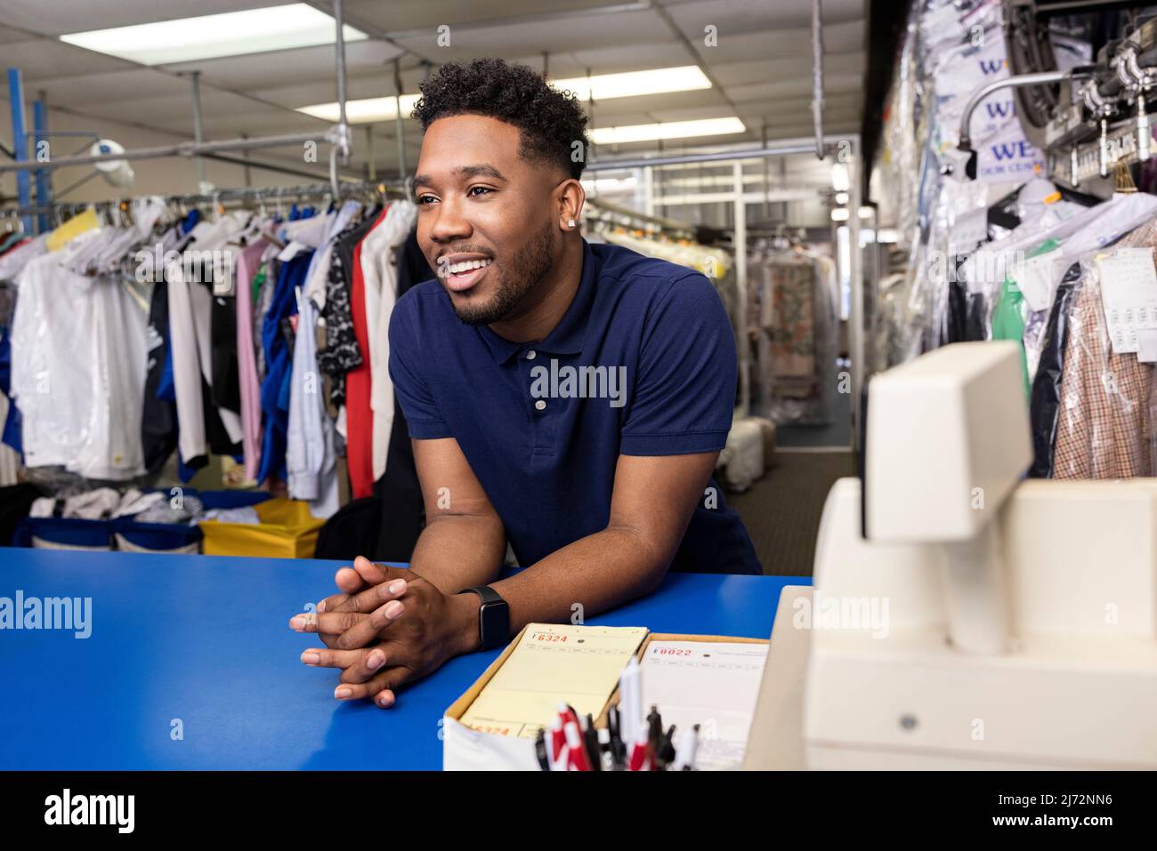 Portrait of man behind counter at dry cleaner Stock Photo - Alamy