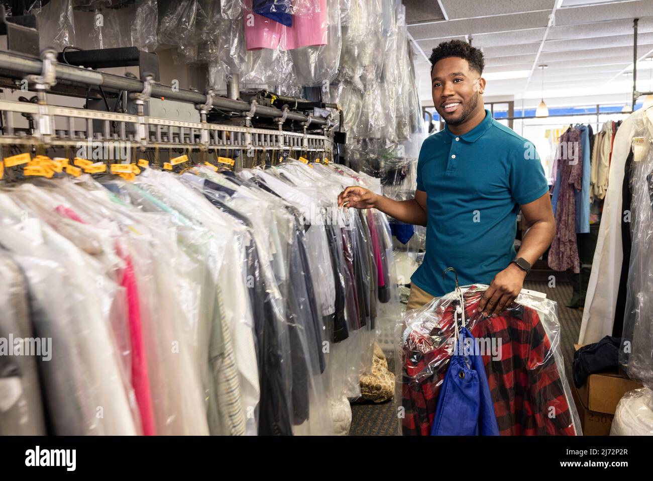 Young male African American employee working at a dry cleaners Stock ...
