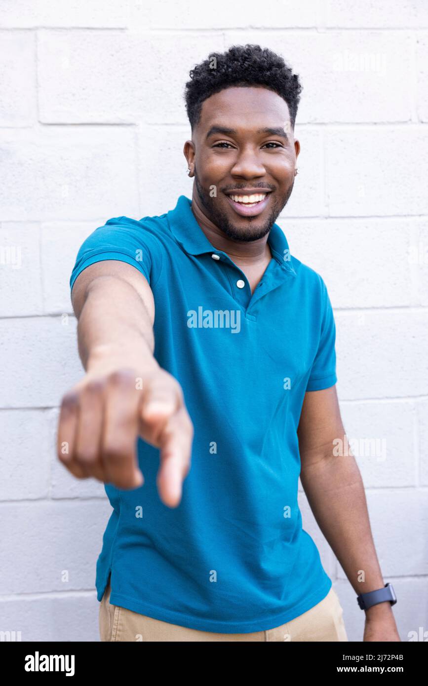 Portrait of a young Black man in a blue polo shirt standing outside ...