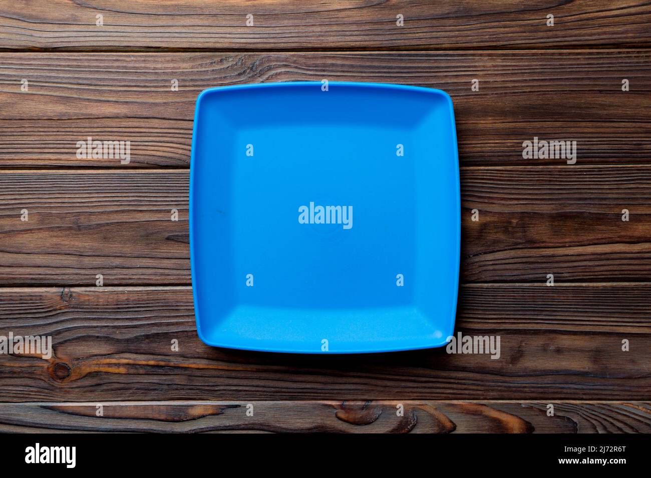 Top view of empty square plate on wooden background. Empty space for ...