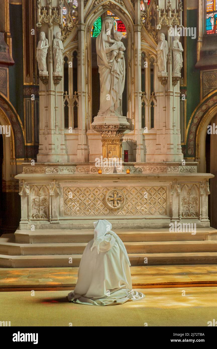 A nun in front of the altar of the Chapel of the Virgin, meditating ...