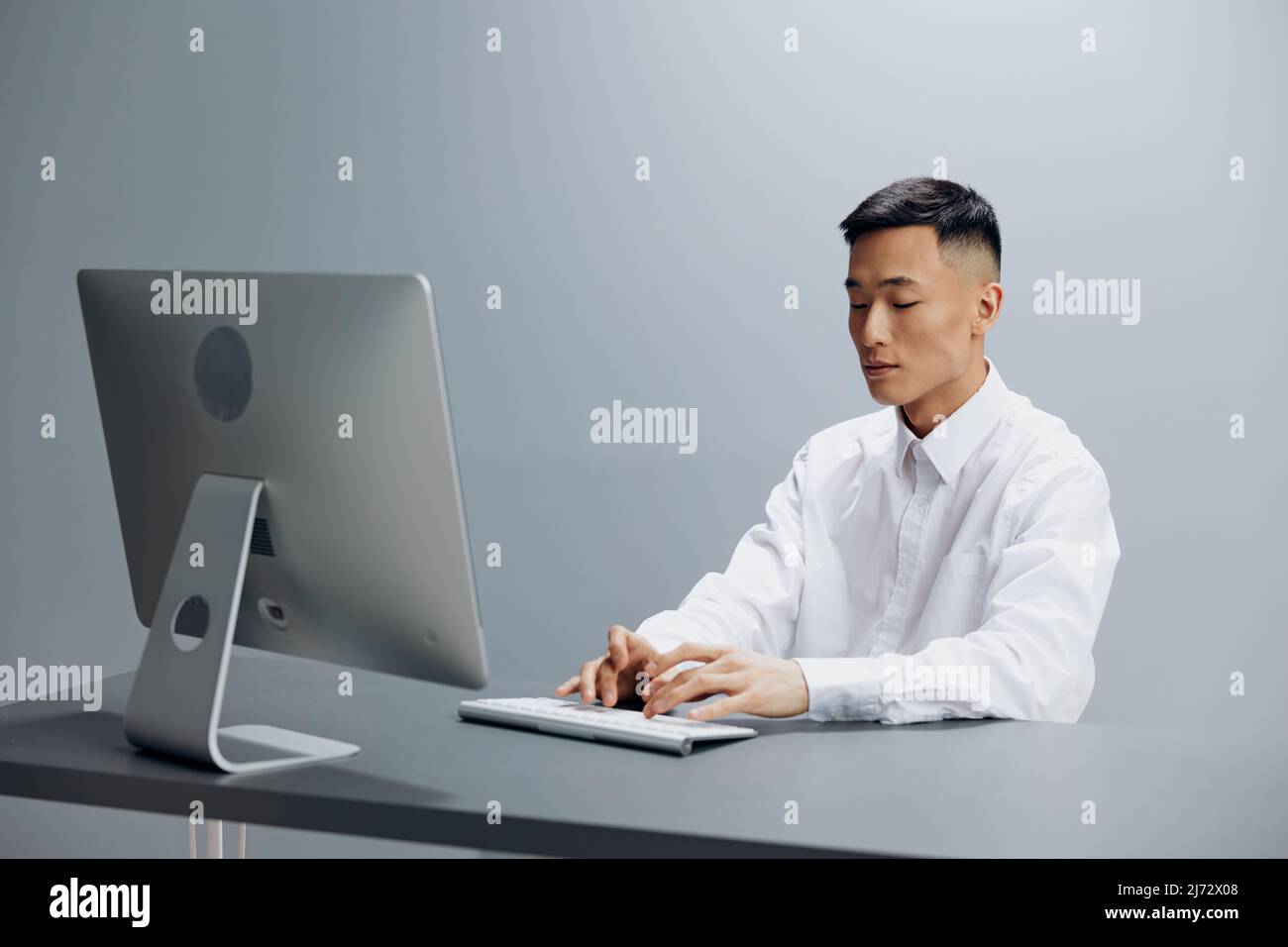 man sits at a computer in the office with a keyboard isolated ...