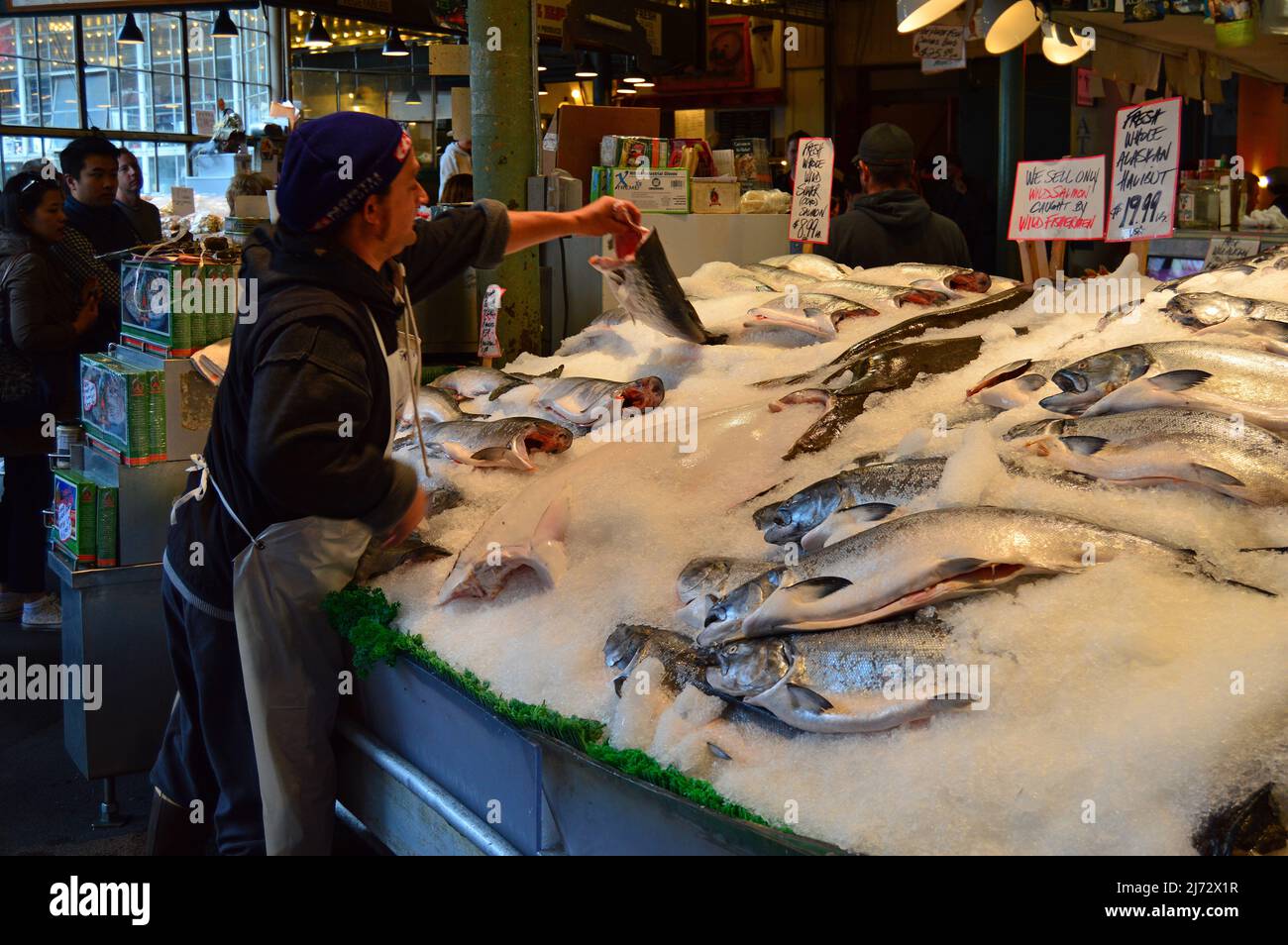 A male worker arranges the catch at the Pike Street Fish Market in ...
