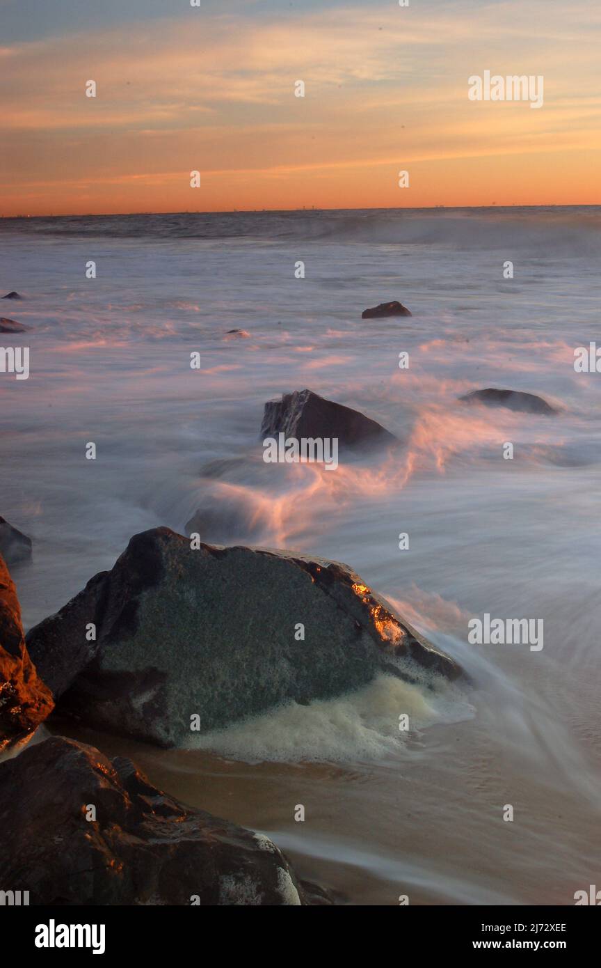 Waves wash around a stone jetty Stock Photo - Alamy
