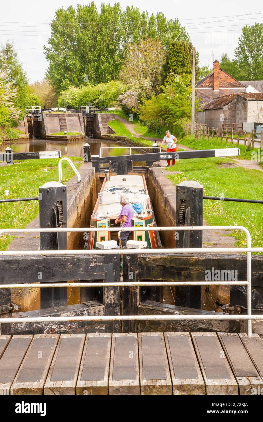 Canal narrowboat passing through locks on the Trent and Mersey canal as ...