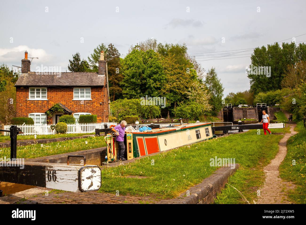 Canal narrowboat passing through locks on the Trent and Mersey canal as ...