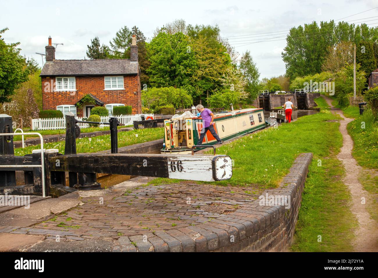 Canal narrowboat passing through locks on the Trent and Mersey canal as ...