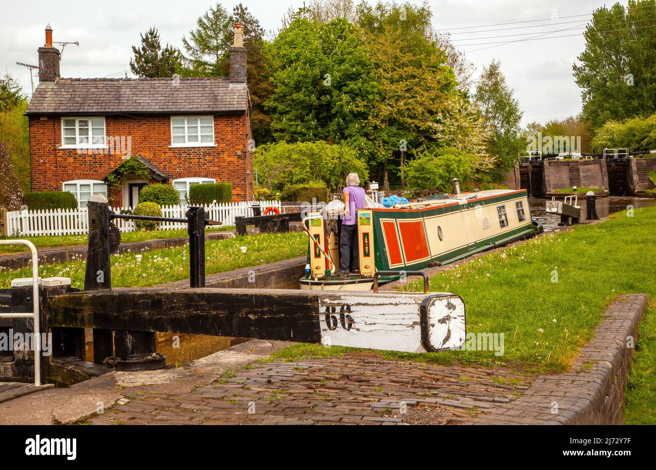 Canal narrowboat passing through locks on the Trent and Mersey canal as ...
