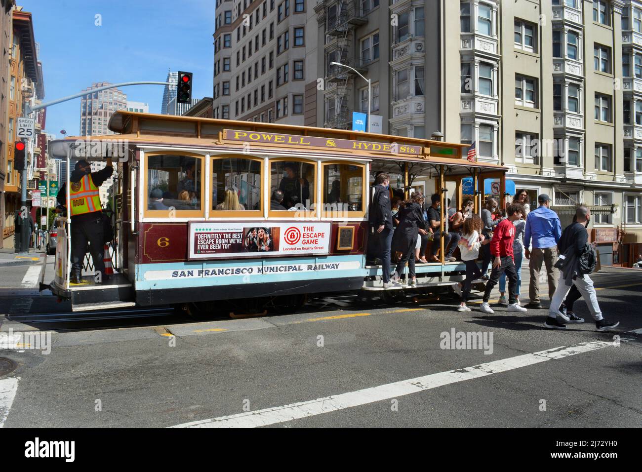 A vintage streetcar stops at an intersection to pick up and drop off ...