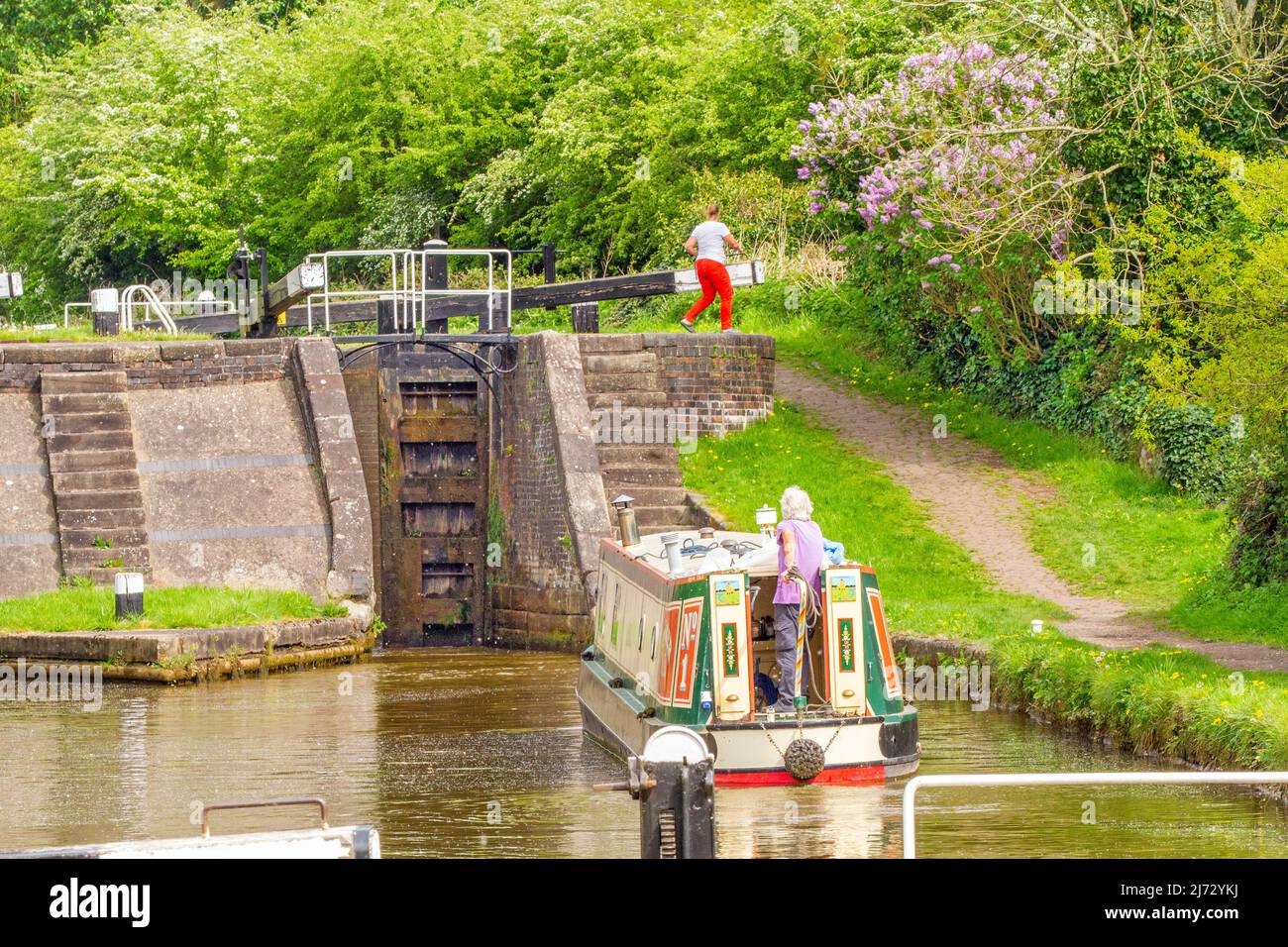 Canal narrowboat passing through locks on the Trent and Mersey canal as ...