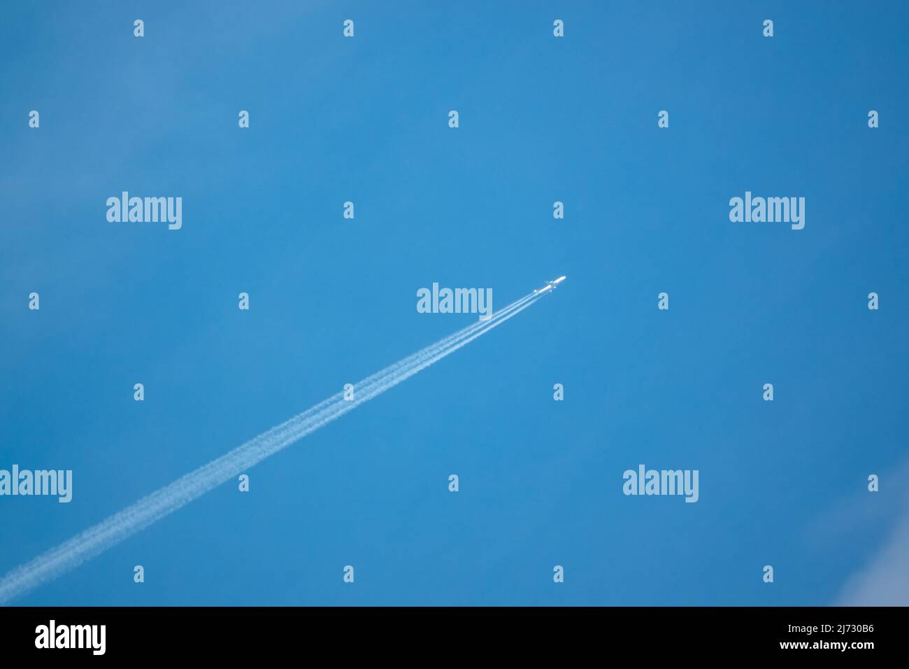 diagonal lower left to upper right high altitude contrails from a twin ...