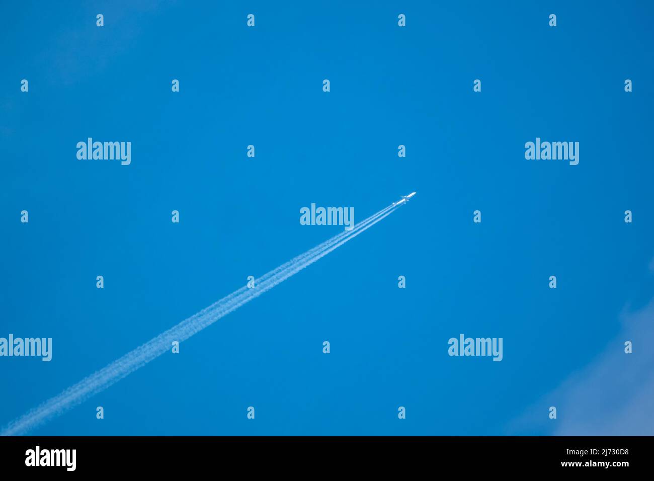 diagonal lower left to upper right high altitude contrails from a twin ...