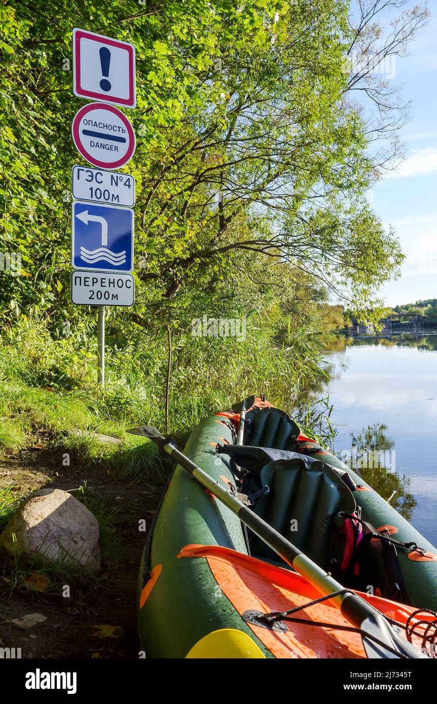 Kayaking on the riverbank. Warning signs on the water in front of the ...