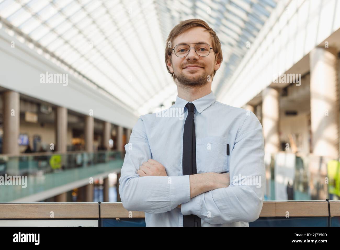Portrait of handsome cheerful intelligent man in glasses over modern ...