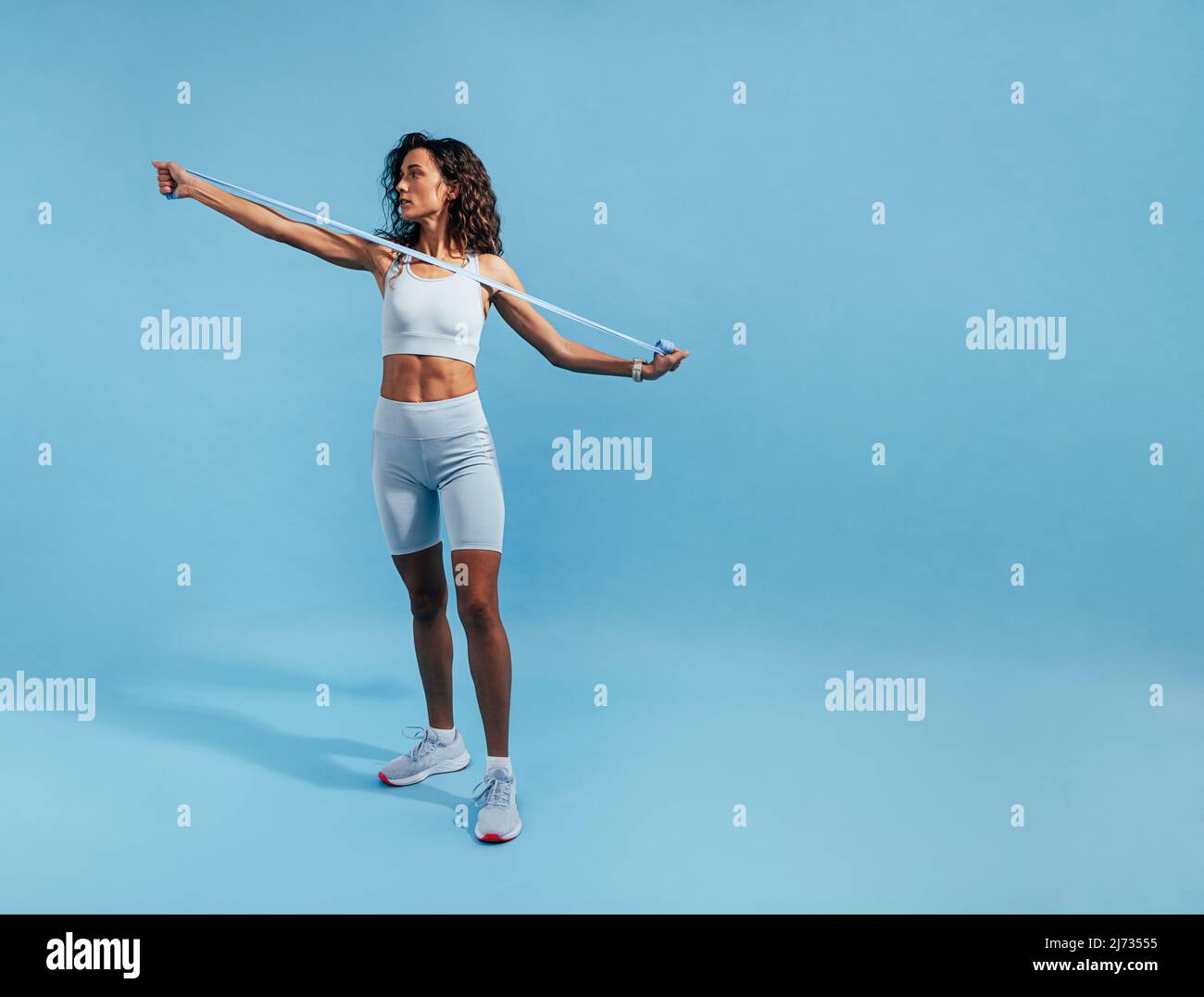 Strong woman using a resistance band. Fitness female doing stretching ...