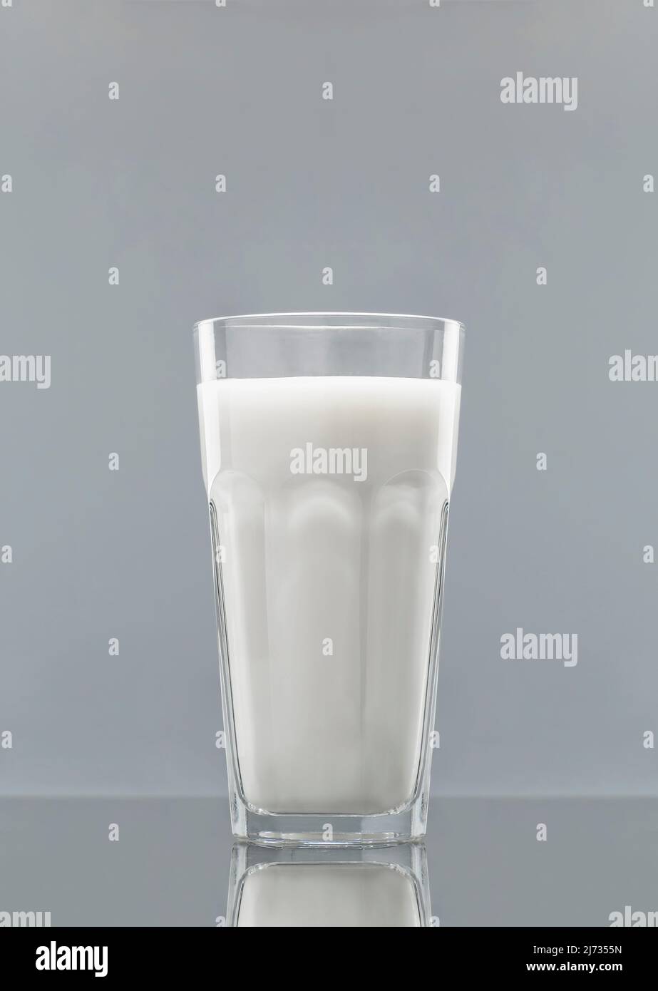 Close up of a glass of milk against grey background Stock Photo - Alamy