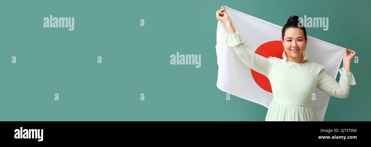 Beautiful young Asian woman holding flag of Japan on green background ...
