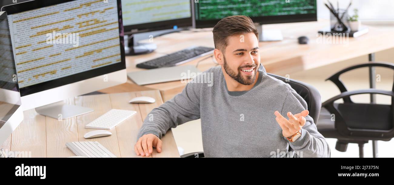 Male programmer talking to colleague in office Stock Photo - Alamy