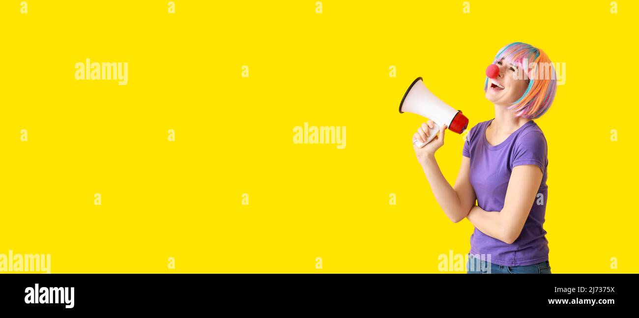 Funny woman in disguise holding megaphone on yellow background with ...