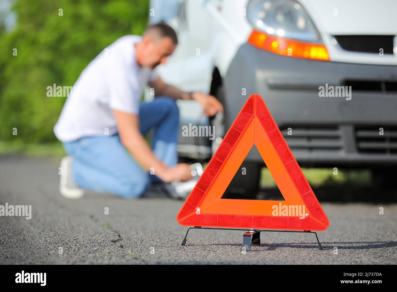 Emergency triangle stop sign and man near broken car on road Stock ...