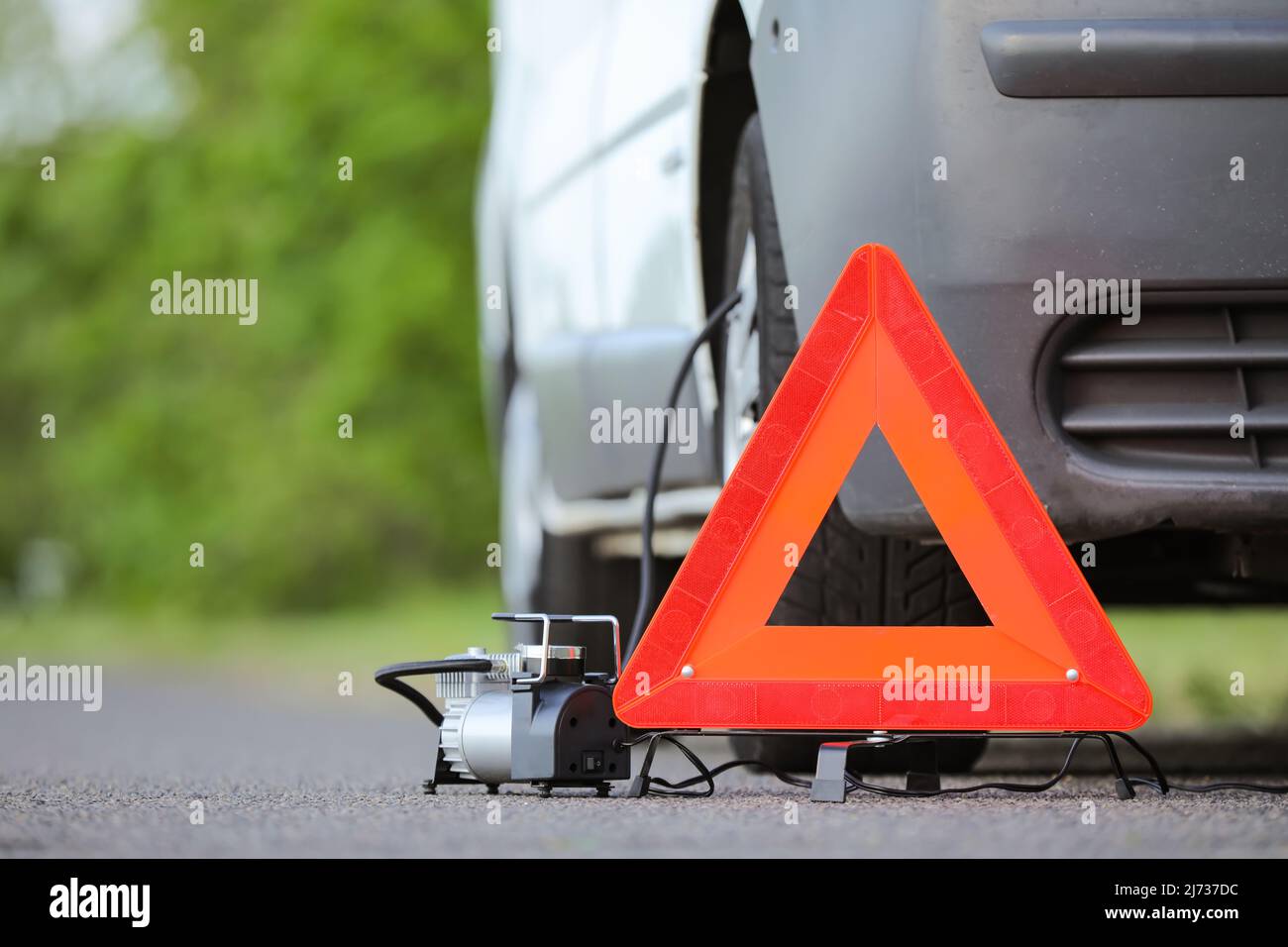 Emergency triangle stop sign and broken car on road Stock Photo - Alamy