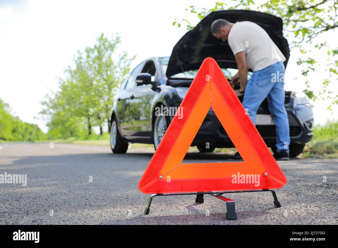 Red emergency stop sign and man near broken car Stock Photo - Alamy