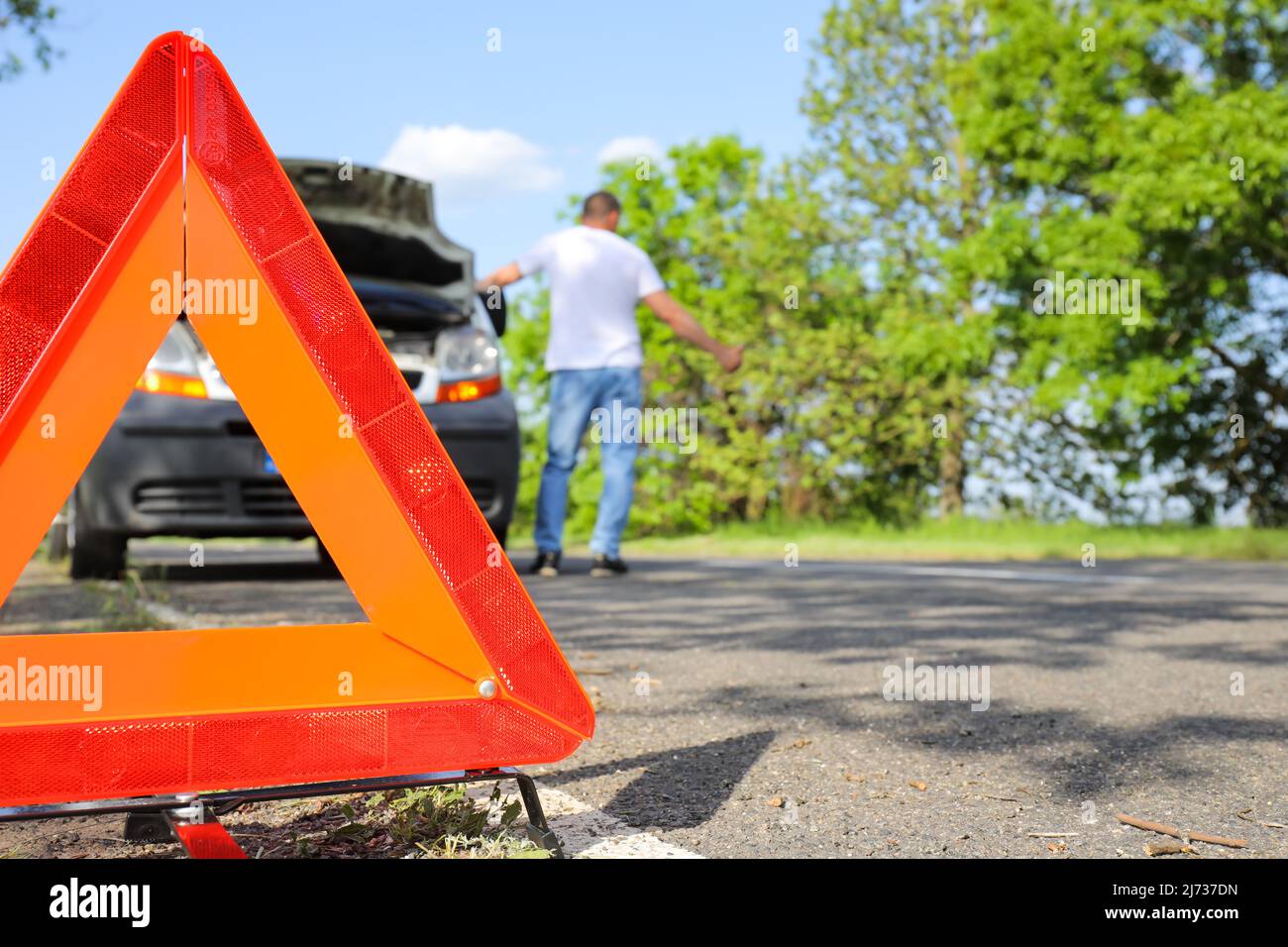 Emergency triangle stop sign, broken car and voting man on background ...